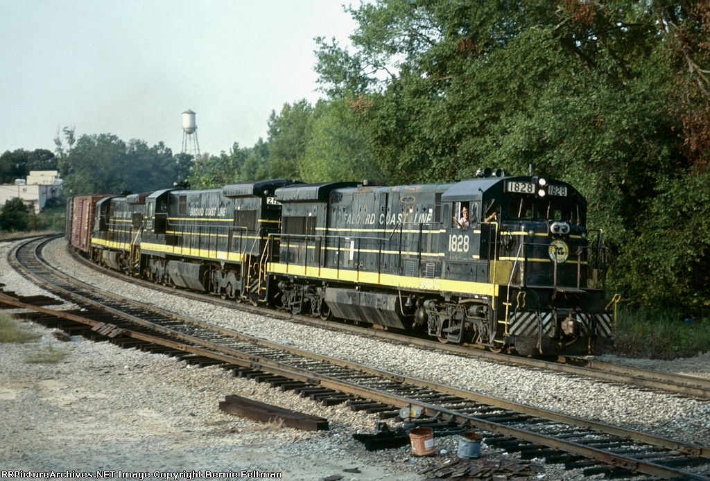 Seaboard Coast Line U36B #1828, leading SCL train #323, with the engineer waving with his right ...